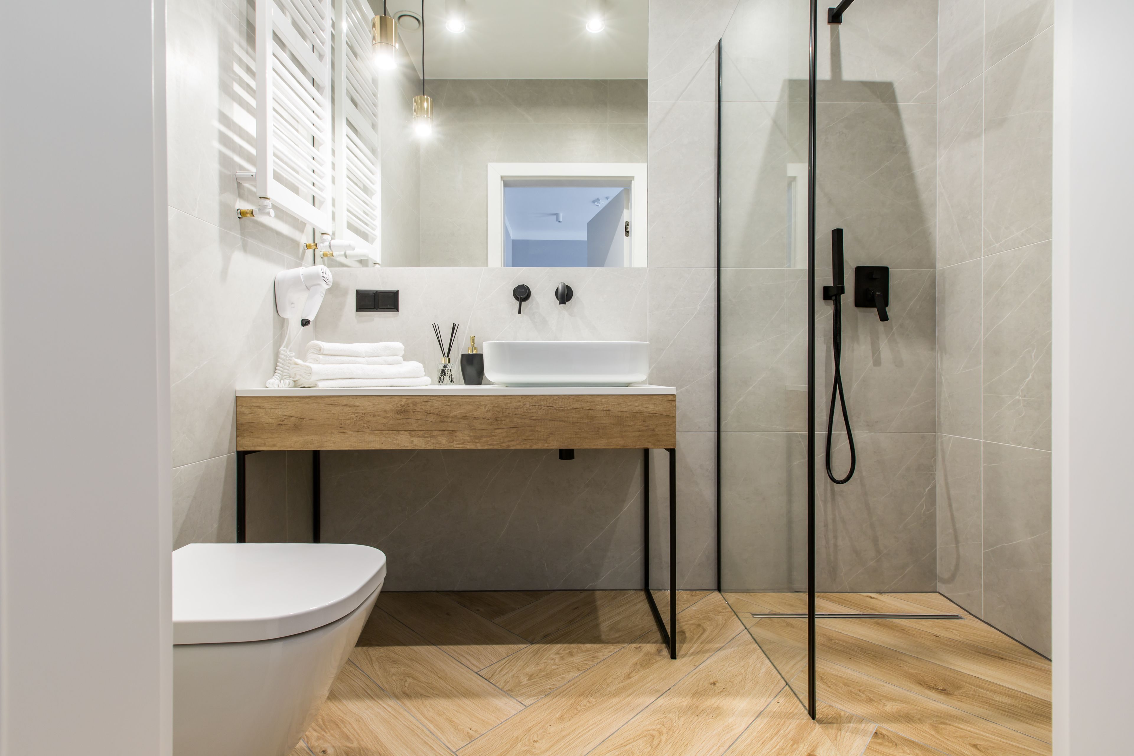 Uma casa de banho moderna com sanita, lavatório e chuveiro.