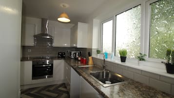 Um frigorífico, um micro-ondas, um forno, uma placa de cozinha