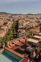 Uma área de piscina no terraço com espreguiçadeiras, um toldo e vista para o horizonte da cidade.