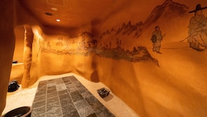 Quarto com um mural retratando uma cena tradicional, piso de azulejos e teto com iluminação embutida.