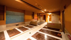 Um saguão de hotel com piso de azulejos, parede com padrão em mosaico e um balcão de recepção.