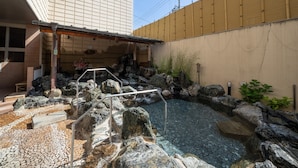 Um jardim japonês tradicional, com lago de carpas, degraus de pedra e cerca de madeira.