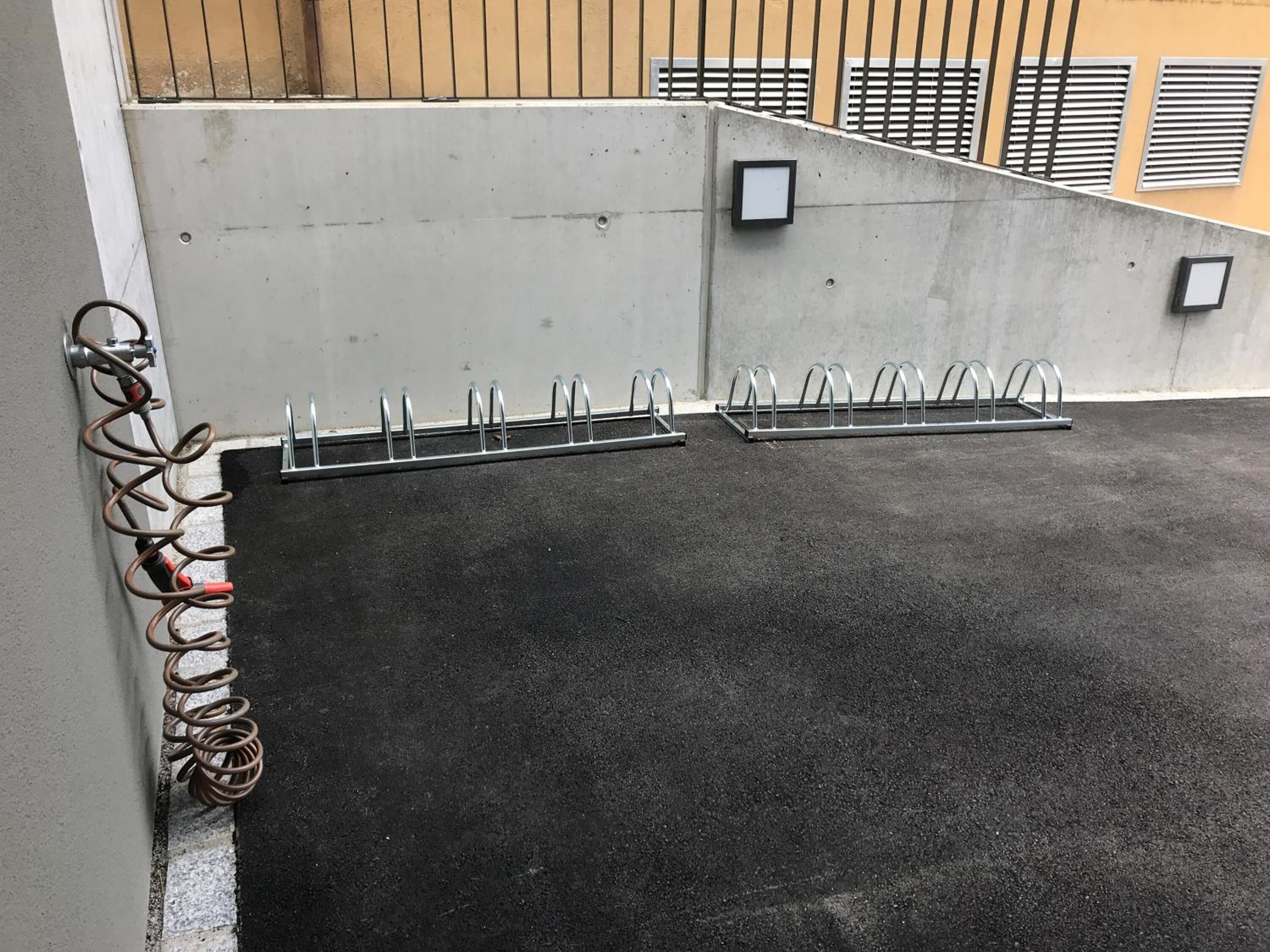 Uma área de estacionamento com uma rampa de concreto que leva à entrada de um edifício.