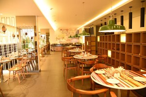 Um restaurante com mesas e cadeiras de madeira, um espaço de bar e uma parede com um mapa decorativo.