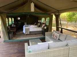 Alojamento em tenda com cama, sofá e área de refeições.