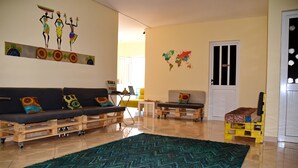 Uma sala de estar com um conjunto de sofá, uma mesa de centro e um tapete colorido.