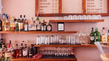 Uma área de bar com prateleiras de garrafas de bebidas e copos.