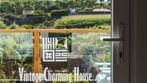 Uma porta de vidro com um logotipo e a inscrição "Vintage Charming House".