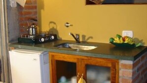 Uma cozinha compacta com geladeira, pia e fogão.