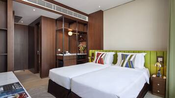 Quarto de hotel com cama grande, escrivaninha, guarda-roupa e toucador.