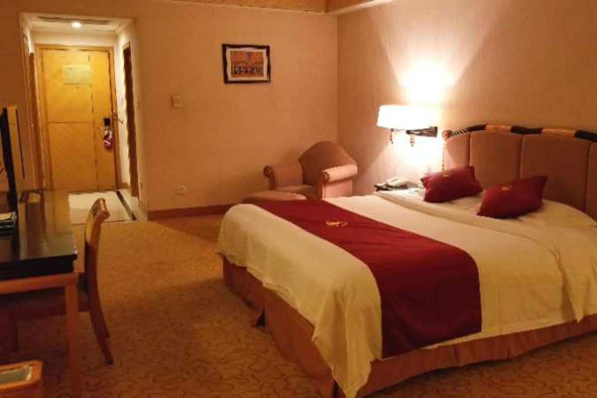 Quarto de hotel com uma cama grande, uma mesa e uma cadeira.