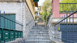 Uma escadaria de pedra leva a um edifício com cerca de metal verde em ambos os lados.