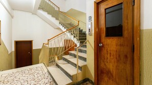 Escada com corrimão de madeira e porta com janela.