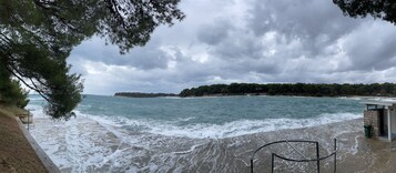 Perto da praia, areia branca, espreguiçadeiras, guarda-sóis