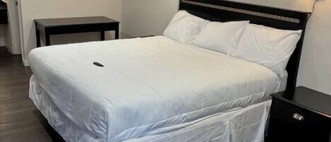 Cama bem arrumada com lençóis brancos em quarto de hotel.