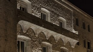 Um edifício de pedra com janelas em arco e varanda.