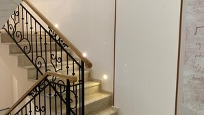Escadaria com corrimão em ferro negro e degraus cor de bege.
