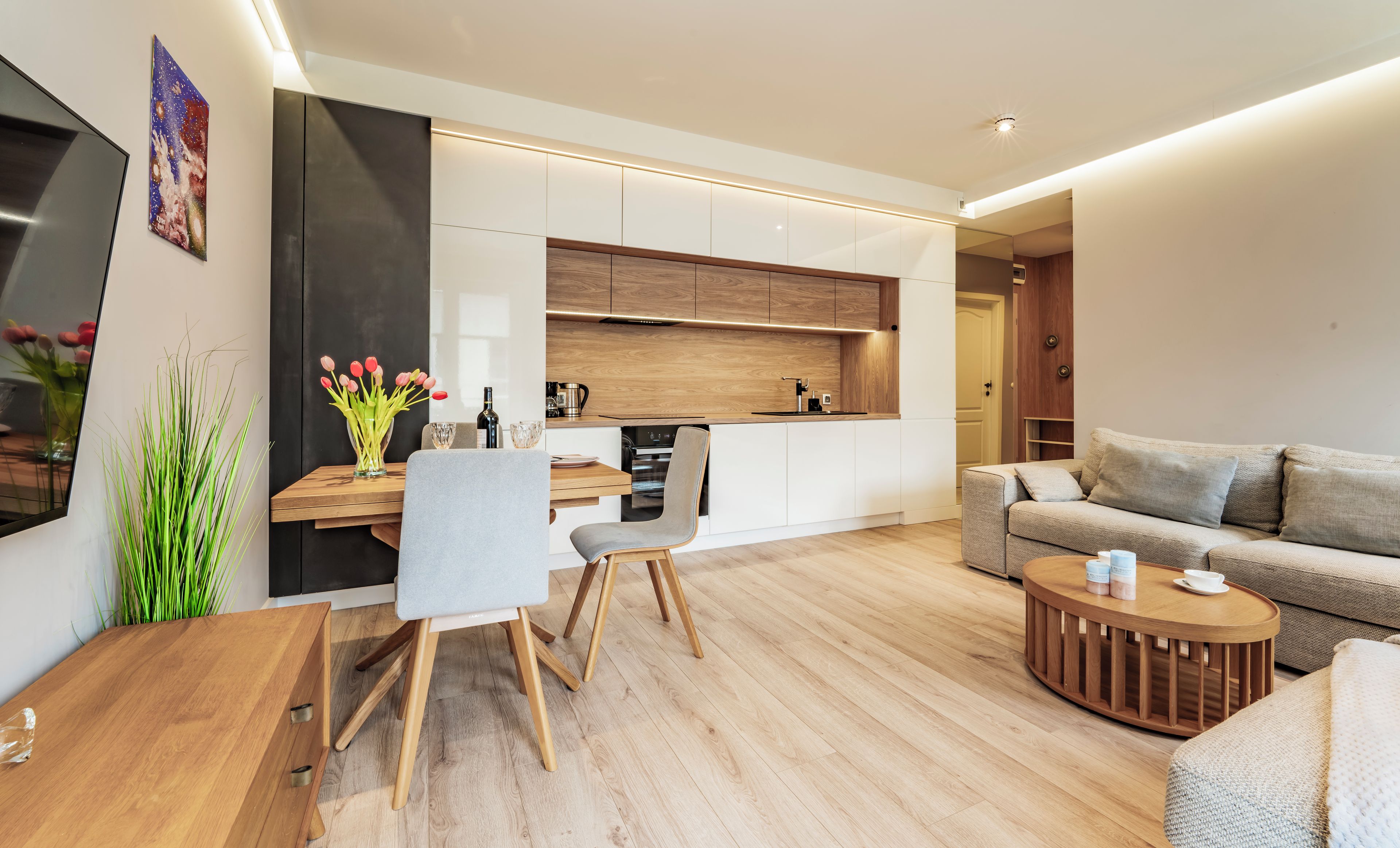 Um apartamento moderno com cozinha, sala de jantar e sala de estar.