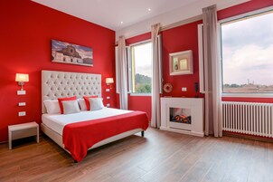 Quarto com uma cama grande, lareira e vista para a cidade.
