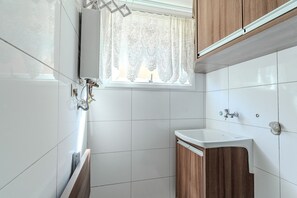 Apartamento Deluxe, 2 quartos, vista para o jardim (Térreo) | Casa de banho | Um polibã, um secador de cabelo, toalhas fornecidas 