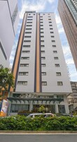 Um edifício alto de hotel com design moderno, apresentando uma placa grande com o nome