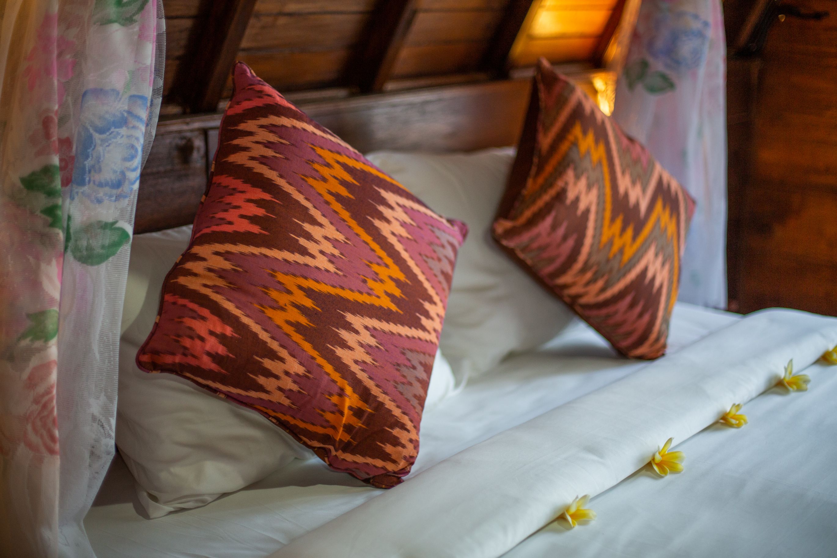 Uma cama com almofadas estampadas e um cobreleito floral.