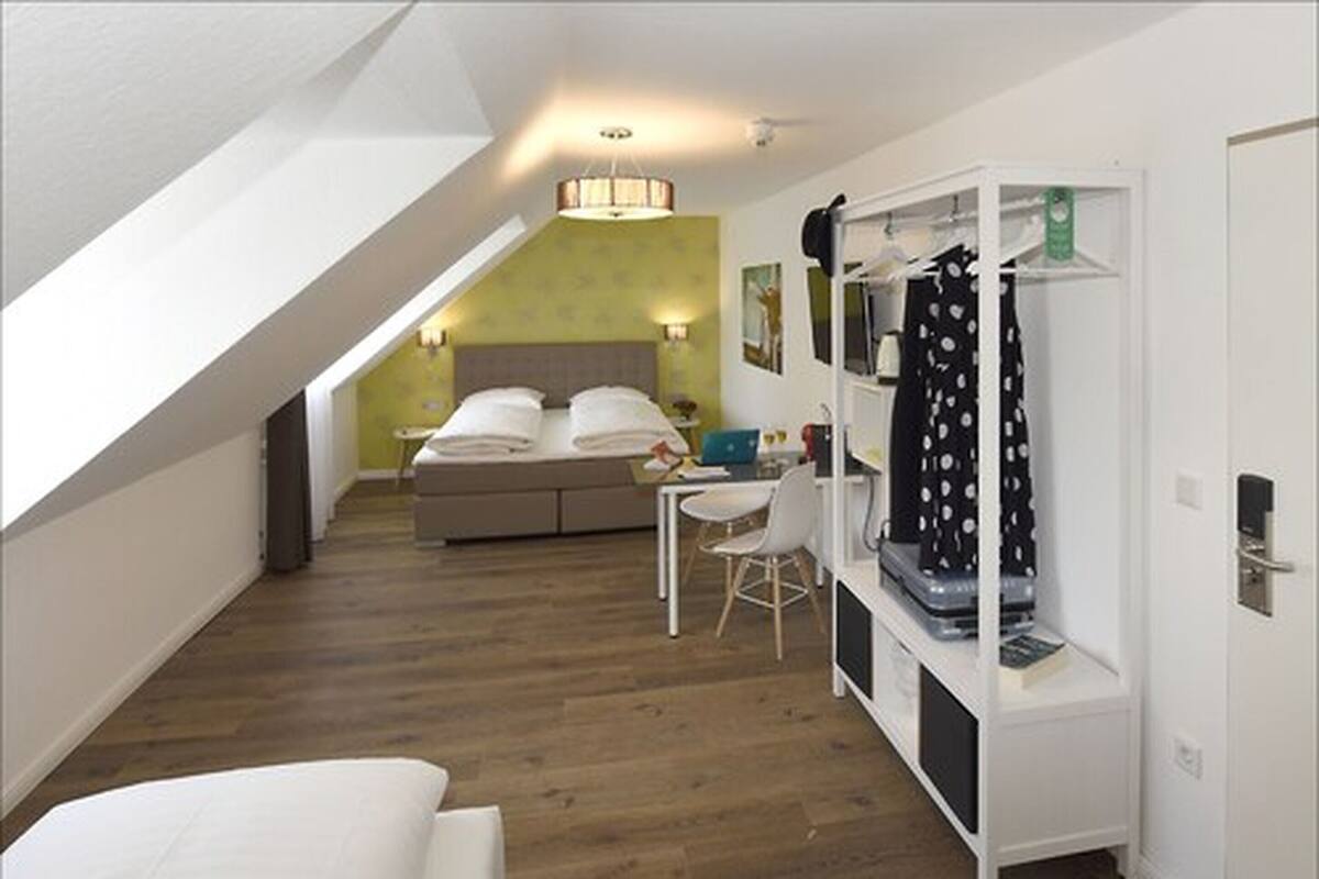 Quarto com cama, escrivaninha e guarda-roupa.
