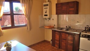 Cozinha com janela, fogão e armários de madeira.