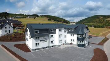 Hotel com design moderno, estacionamento e vista para a paisagem ao redor.
