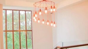 Uma escadaria moderna com guarda-corpos de vidro e um design geométrico no teto.