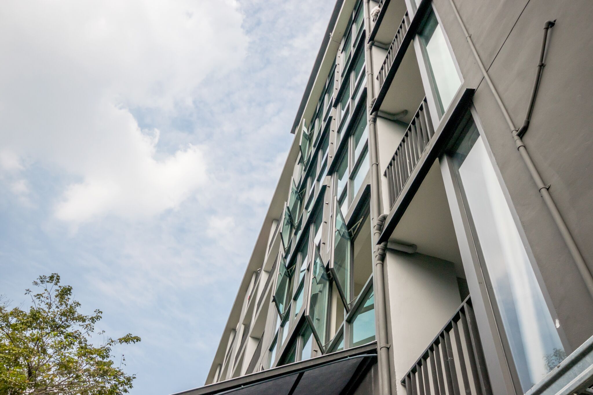 Um edifício de vários andares com design arquitetônico moderno, com grandes janelas e sacadas.