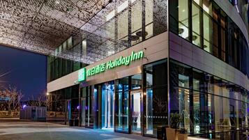 Um hotel Holiday Inn com fachada de vidro moderna e padrão de teto característico.