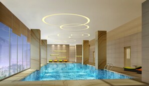 Piscina interior moderna com águas cristalinas, rodeada por amplas janelas e design minimalista.