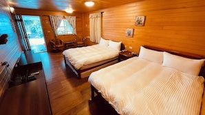 Quarto de cabana de madeira com duas camas, uma escrivaninha e uma cadeira.