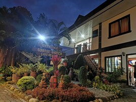 Uma área de jardim bem iluminada com uma placa que diz 'Welcome Sunrise Garden Lake Resort'.