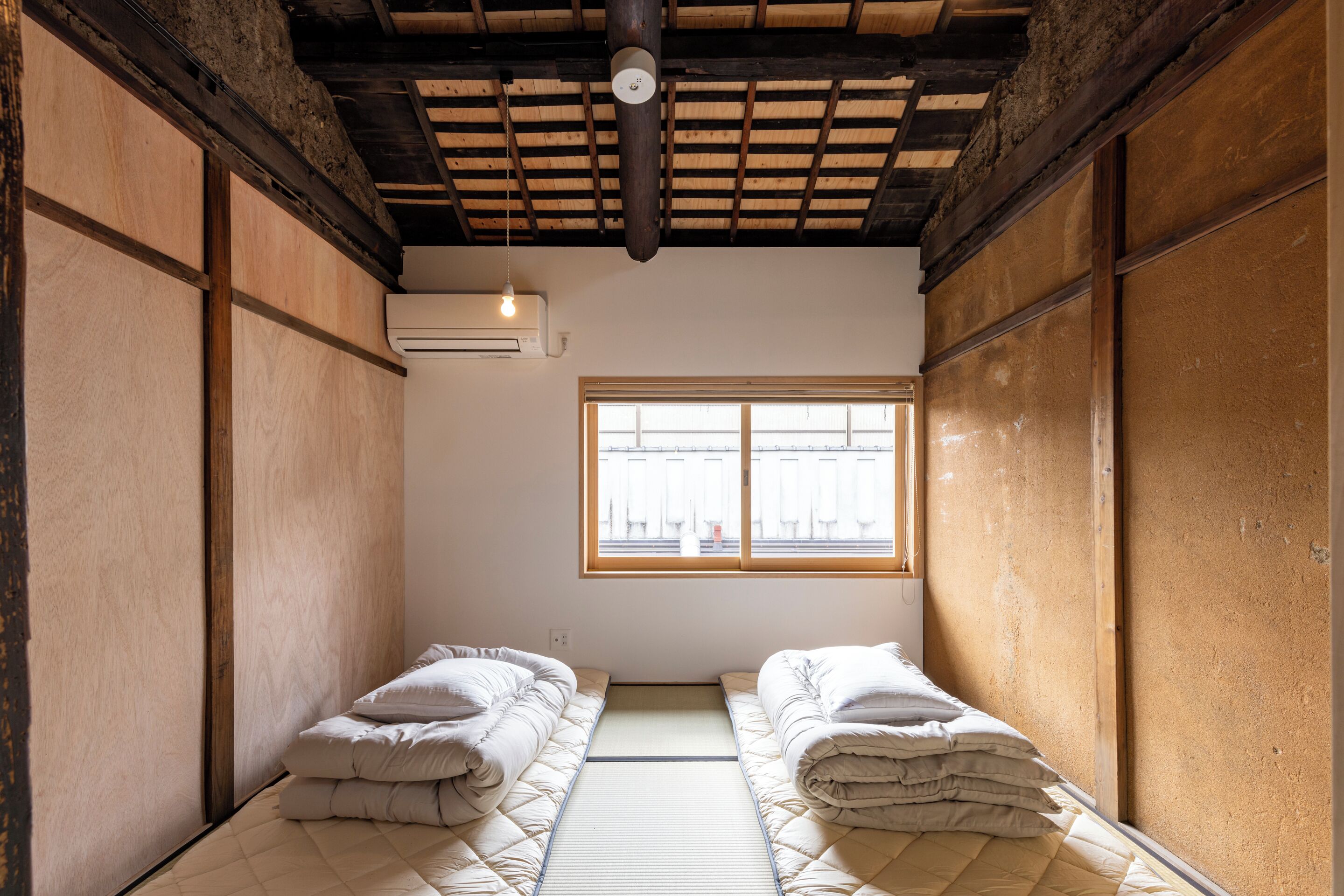 Um quarto japonês tradicional com tatames, um biombro shoji e uma cama futon.