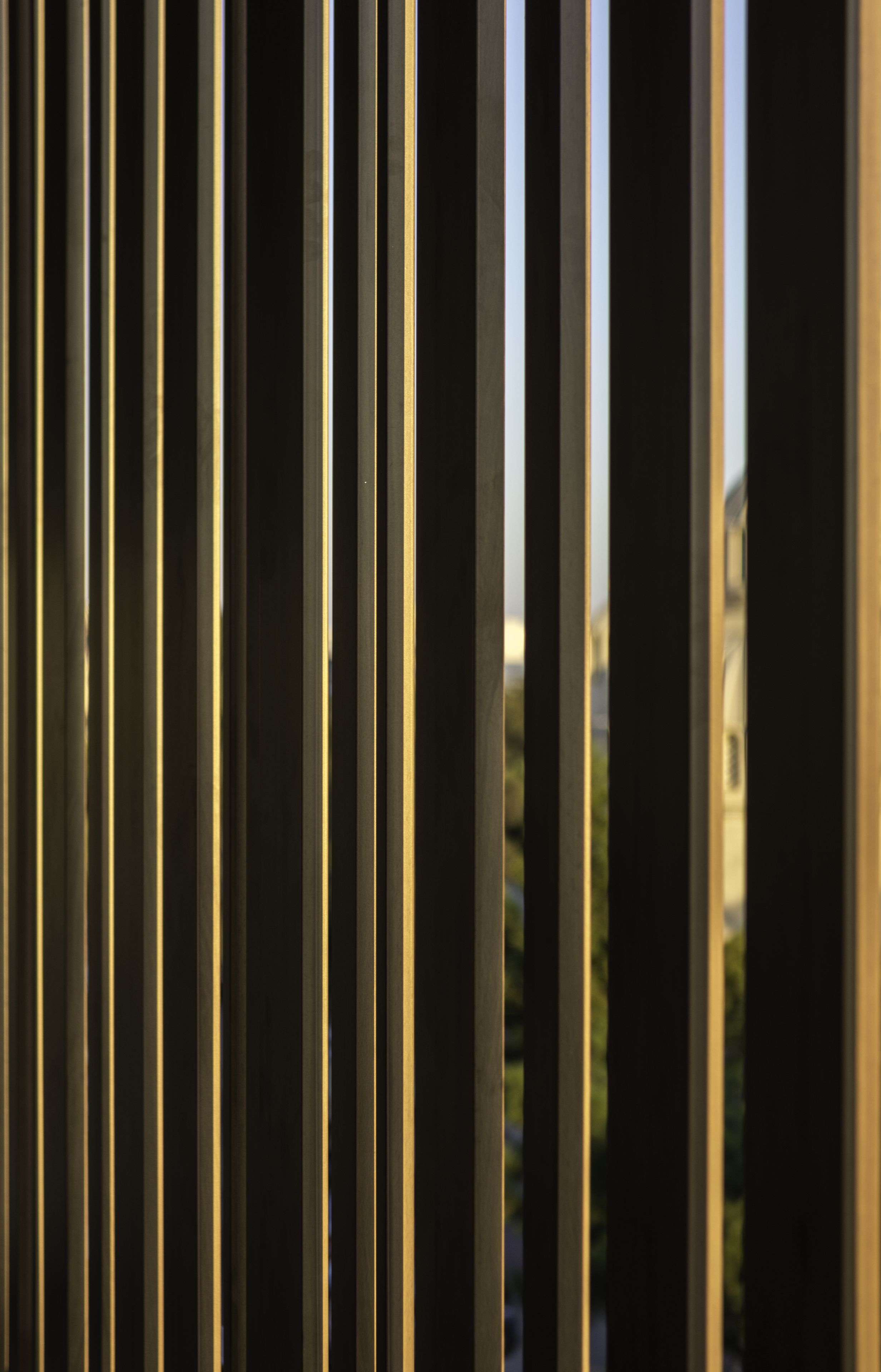 Persianas verticais com vista para um edifício pelas aberturas.