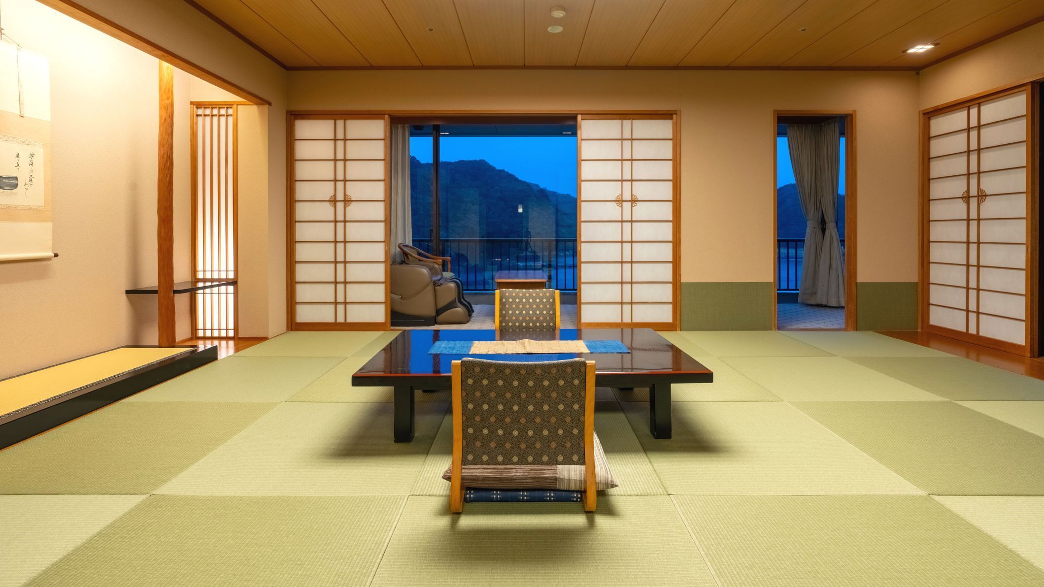 Um quarto japonês tradicional com tatames, uma mesa baixa e portas deslizantes.