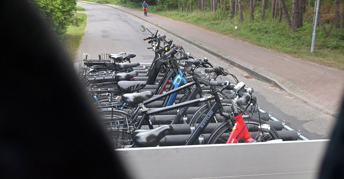 Várias bicicletas estacionadas em um suporte.