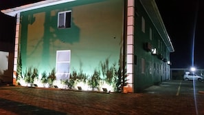Um edifício com fachada verde, uma janela e uma porta pequena.