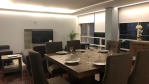 Uma sala de jantar moderna com uma mesa retangular posta para seis pessoas, cercada por seis cadeiras.