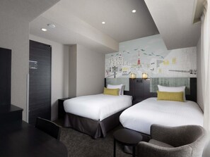 Quarto de hotel com duas camas, uma escrivaninha e uma cadeira.