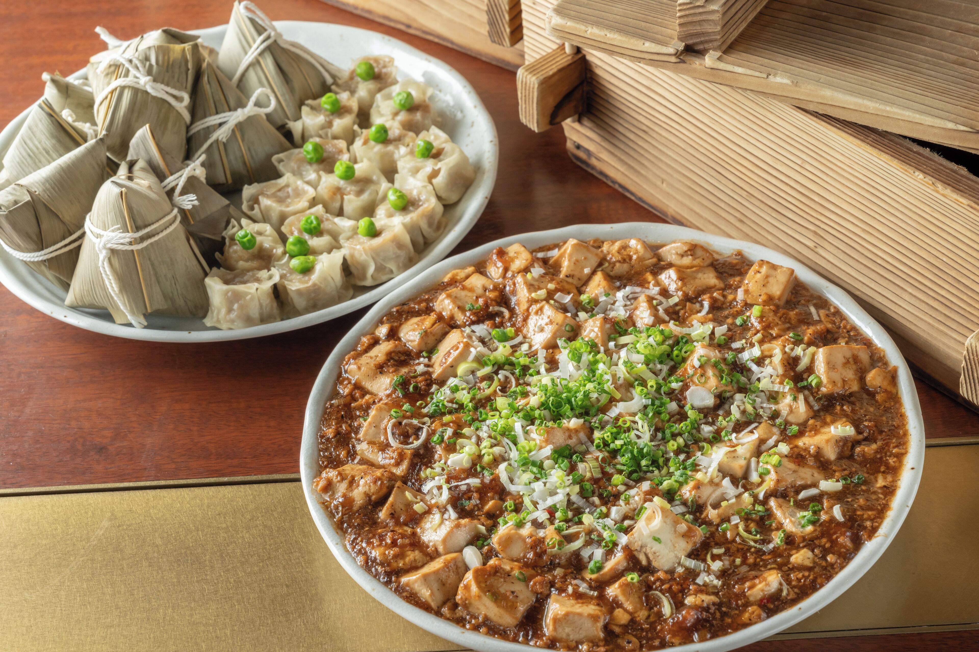 Um prato de dumplings e uma tigela de tofu.