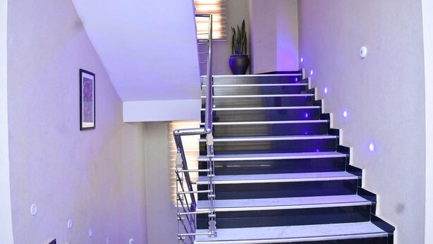 Uma escadaria moderna com grades de metal e degraus iluminados.