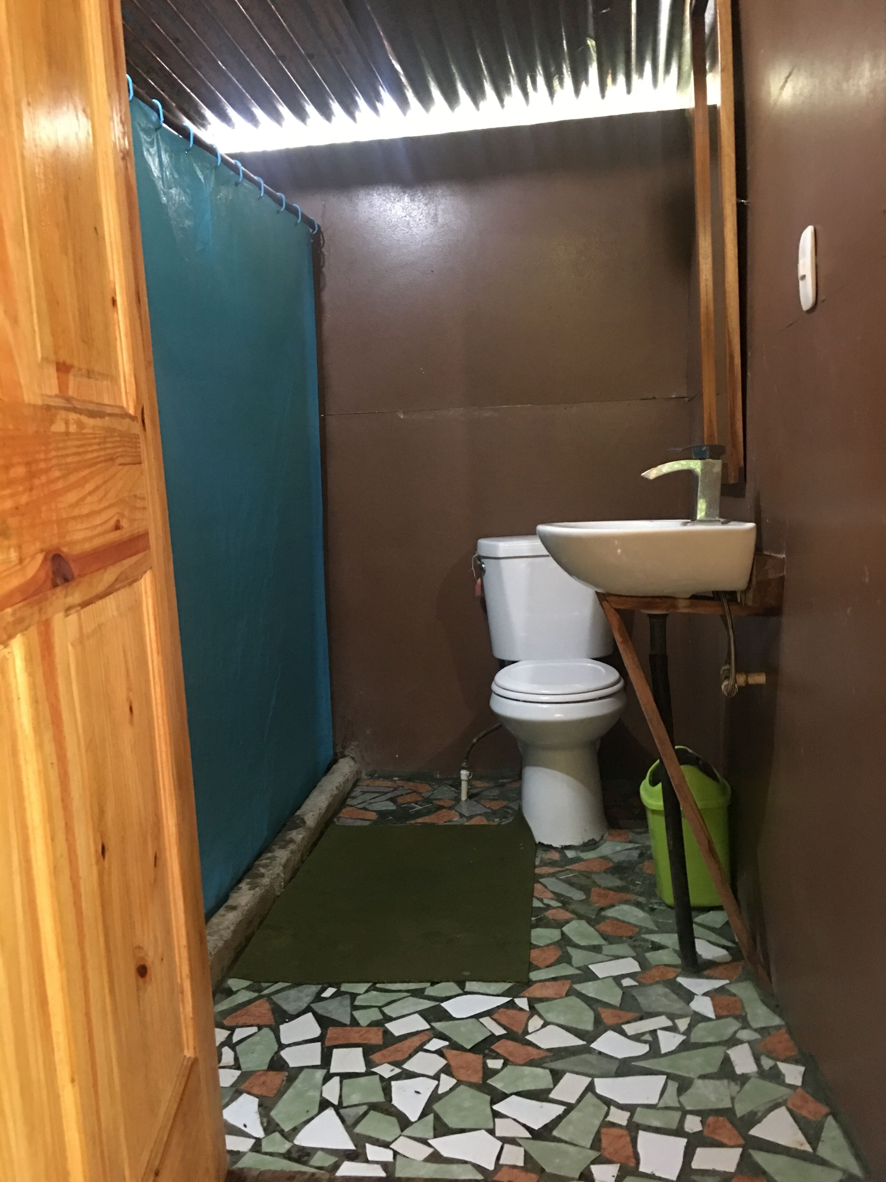 Uma casa de banho pequena com sanita, lavatório e espelho.