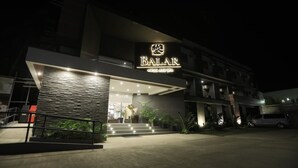 Um hotel chamado Balar, com fachada moderna, entrada bem iluminada e escadaria que leva ao saguão.