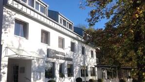 Um edifício branco com uma placa que diz 'Hotel Restaurant'.