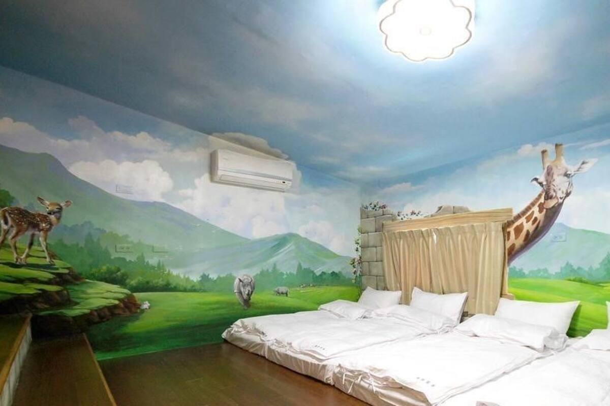Quarto com um mural representando uma paisagem de savana, uma cama e uma janela com cortinas.