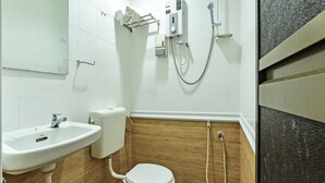 Um banheiro pequeno com vaso sanitário, pia e chuveiro.