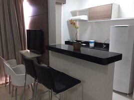 Um frigorífico, um micro-ondas, uma placa de cozinha 